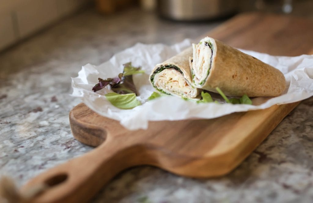 a healthy wrap with turkey, greens and cheese made with whole grain ...